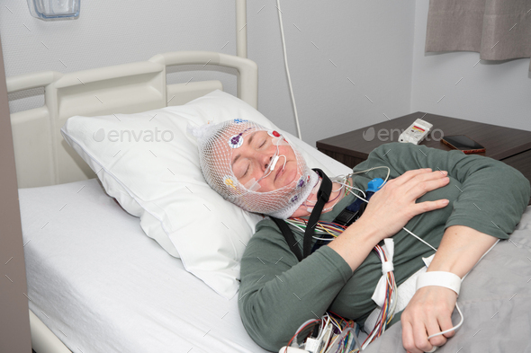 Middle aged woman measuring brain waves, examining polysomnography in ...