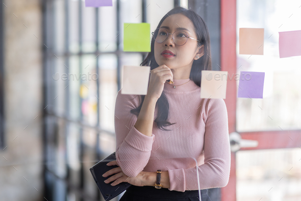 Young Asian woman Creative team use post it notes to share idea sticky ...