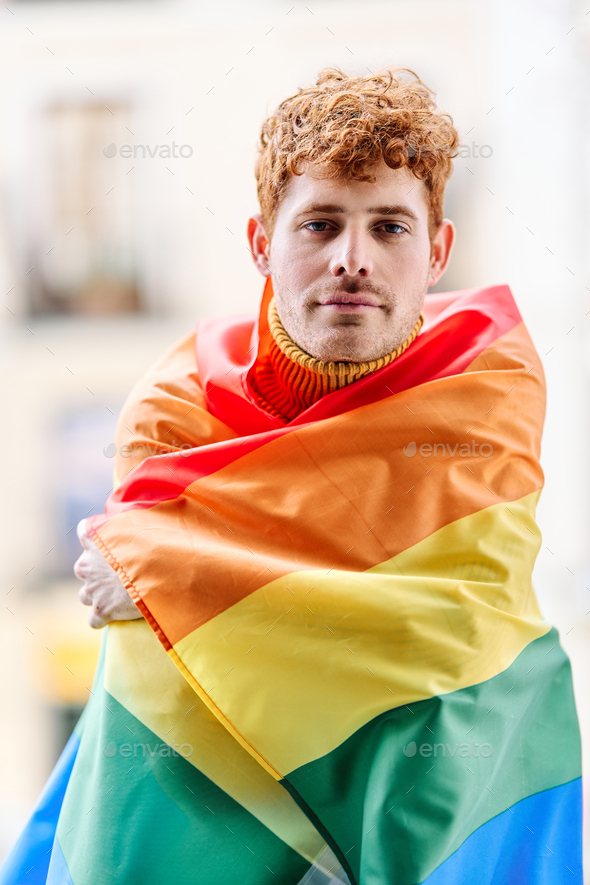 Redheaded gay man wrapping with a rainbow lgbt flag Stock Photo by ...