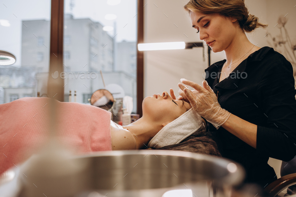 Curing skin problems. Cropped female cosmetologist looking at client's ...