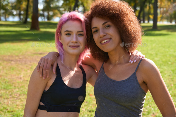 Pleased female athletes hugging each other outdoors Stock Photo by ...