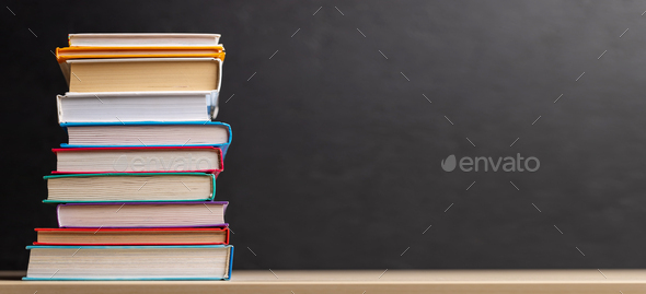 Stack of books on desk with chalkboard Stock Photo by karandaev | PhotoDune