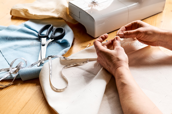 Seamstress basting and sewing in a small studio. Sartorial clothes ...