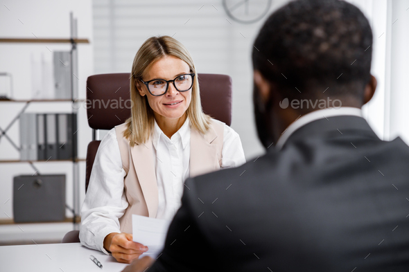 Hiring, interview. Middle-aged blond business woman conducting an ...