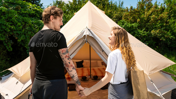 Young couple holding hands near the tent at glamping Stock Photo by ...