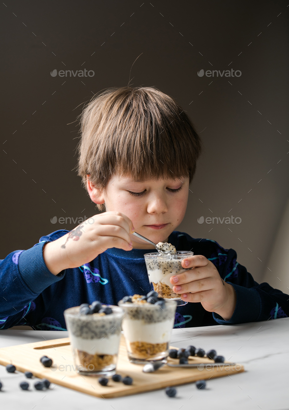Kid eating parfait. Proper kids nutrition concept. Stock Photo by ...