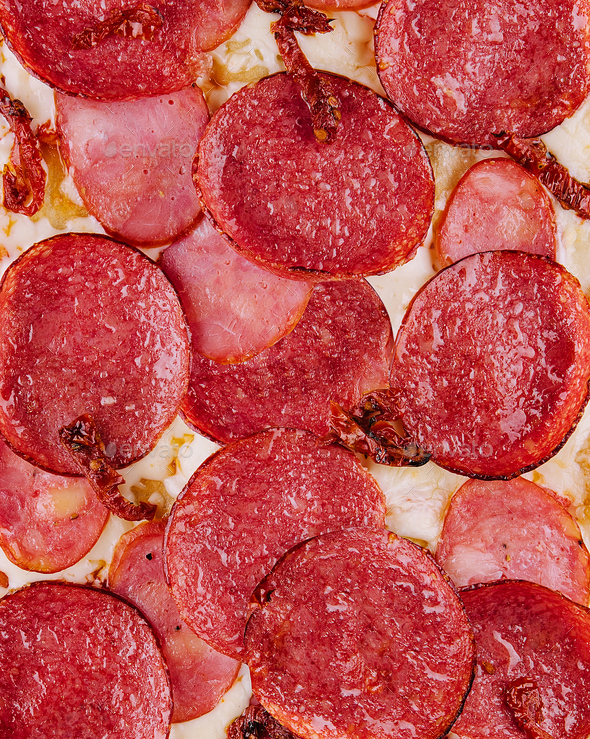 Pepperoni pizza close up background or texture Stock Photo by AntAlexStudio