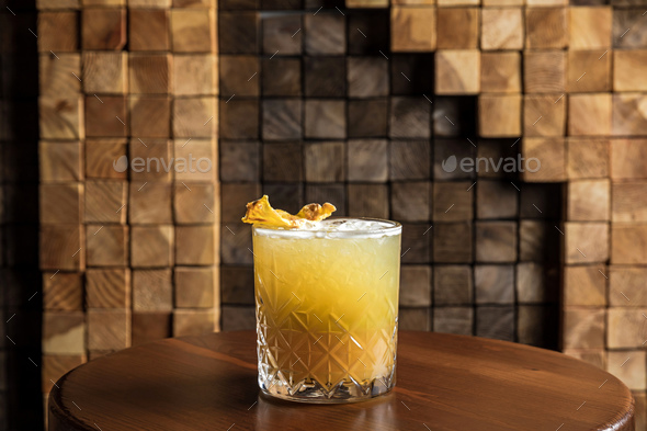 An iced fruity alcoholic cocktail in a lowball rocks glass garnished ...