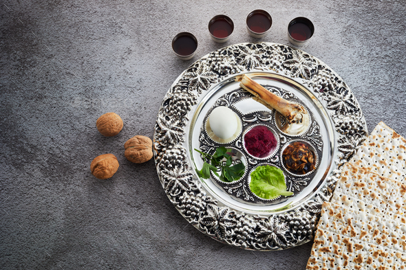 Passover Seder plate with traditional food, walnuts, matza and wine on ...