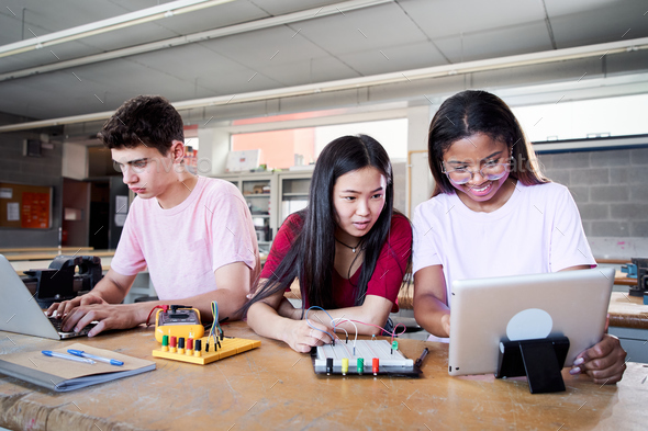 Group of three young students from a technical high school doing a ...