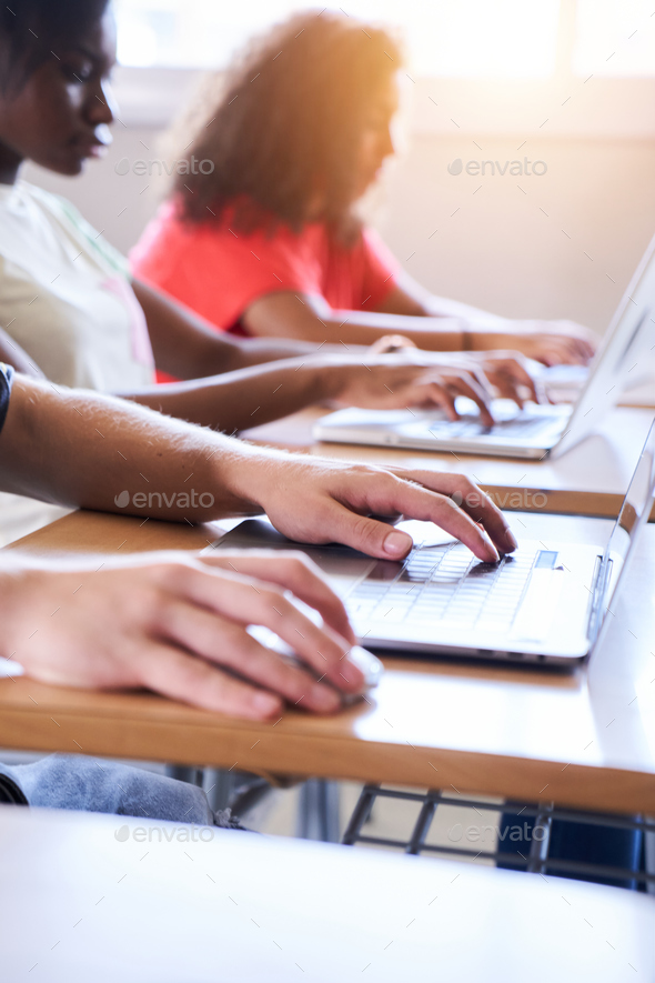 Vertical Close-up of the laptop in the classroom. A multi-ethnic group ...