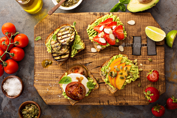 Variety of avocado toasts on a cutting board Stock Photo by fahrwasser
