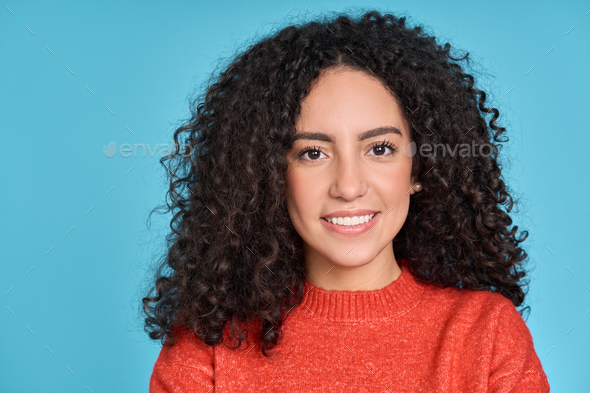Young happy latin woman standing isolated on blue background, portrait ...