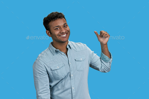 Young smiling south asian man is pointing back with thumb. Stock Photo ...