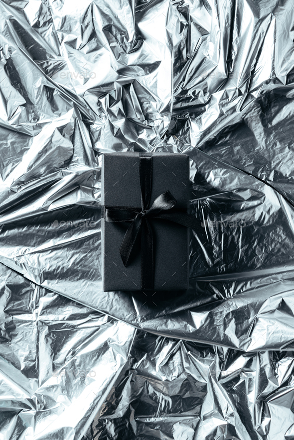 top view of gift box with black ribbon on silver wrapping paper ...