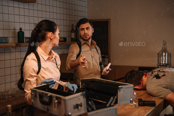 focused female and male detectives using evidence collection kit and ...