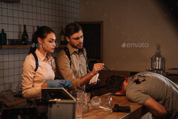 serious female and male detectives using evidence collection kit and ...