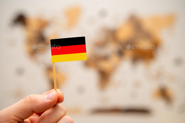 Germany flag in mans hand on the world map background. Stock Photo by ...