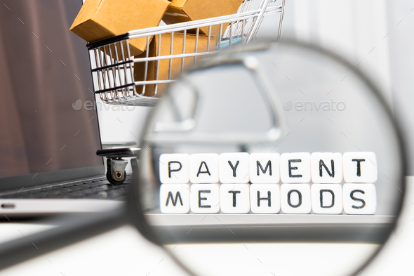 Payment methods on cubes through a magnifying glass Stock Photo by ...