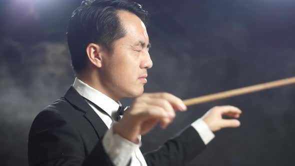 Side View Of Asian Conductor Man Holding A Baton And Showing Gesture ...