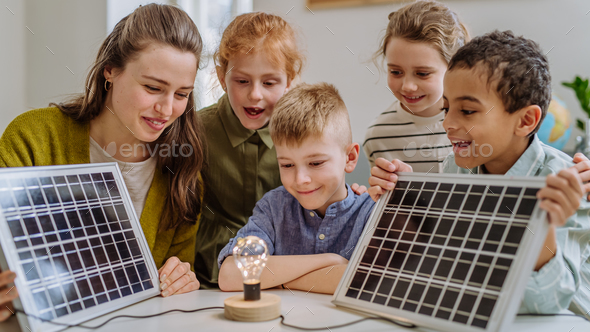 Young teacher with solar panel learning pupils about solar energy ...