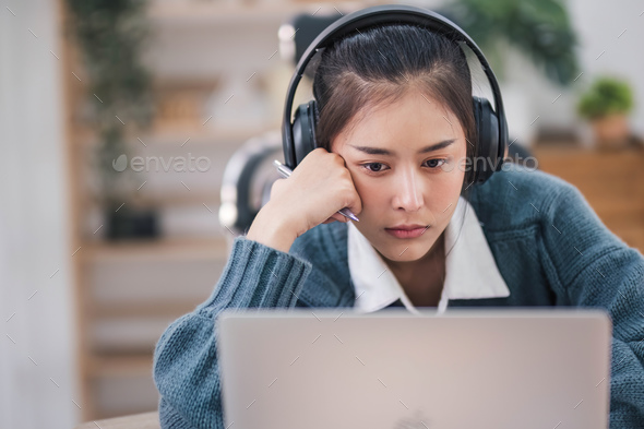 Bored young asian girl student studying, looking upset at laptop screen ...