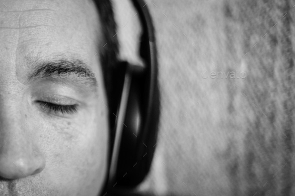 A Close Up Of A Mans Face With His Eyes Closed The Man Is Listening To Music Through