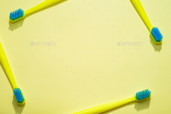 Modern yellow kids toothbrushes on a yellow background arranged in a ...