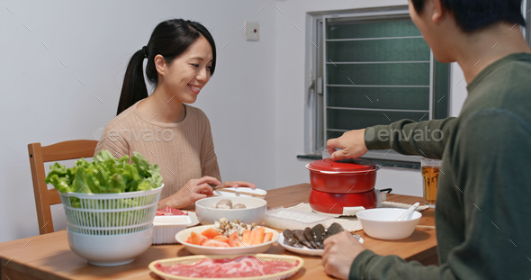 Chinese couple having hot pot at home Stock Photo by leungchopan ...