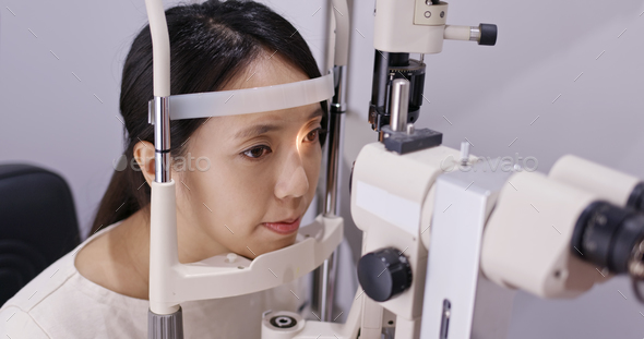 Asian Woman do eye test at clinic Stock Photo by leungchopan | PhotoDune