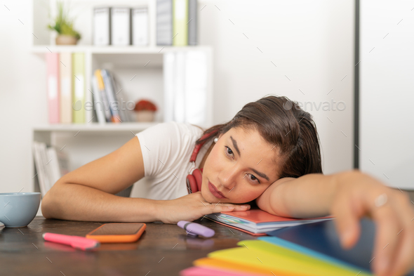 Young woman, tiredly lying on the desk in her apartment Stock Photo by ...