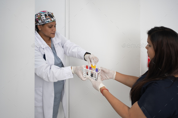 Nurse handing the test tubes to the scientist Stock Photo by GSR ...