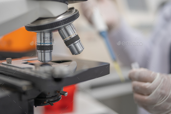 Laboratory technique analyzing a biological test under a microscope ...