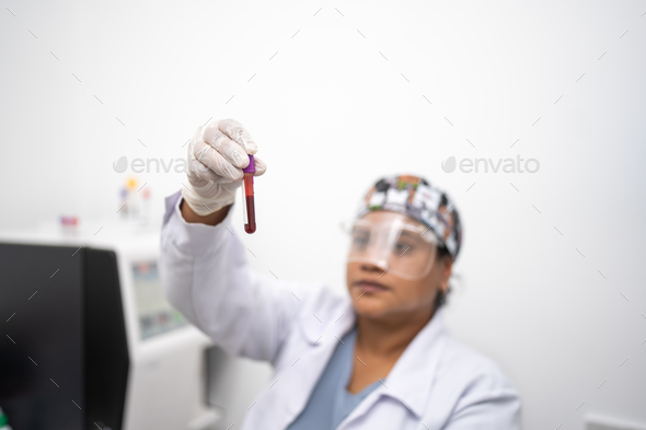 Female lab technician observing that the blood sample is in good ...
