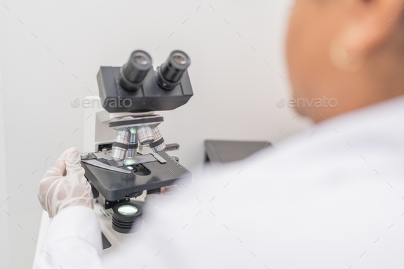 Lab technician using microscope to analyze bacteria Stock Photo by GSR ...