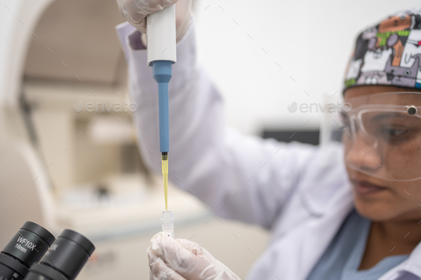 Female laboratory technique, placing a biological sample into a test ...