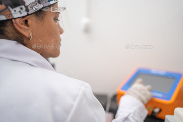 Female lab technician using immunology analyzer Stock Photo by GSR ...