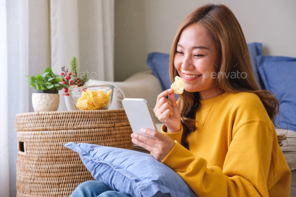 Portrait image of a beautiful young woman using mobile phone while ...