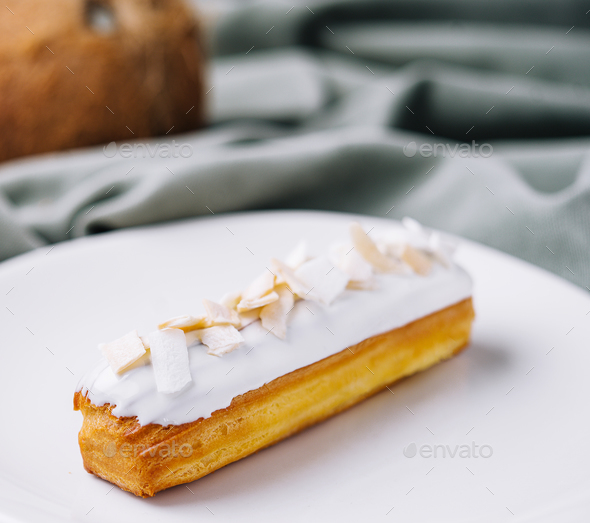 french eclair with coconut on plate Stock Photo by AntAlexStudio ...