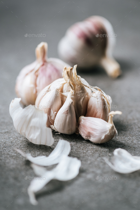 Close up view of ripe garlic bulbs and husk on grey surface Stock Photo ...