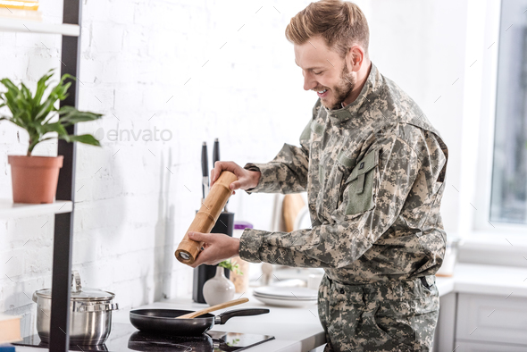 army soldier using pepper pot while cooking in kitchen Stock Photo by ...