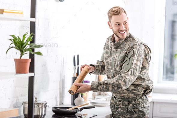 army soldier using pepper pot while cooking in kitchen Stock Photo by ...