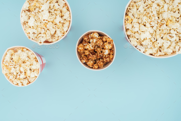 top view of striped buckets with fresh popcorn isolated on blue Stock ...