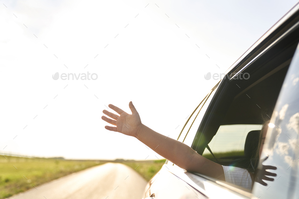 Unrecognizable child showing hand out of running car Stock Photo by ...