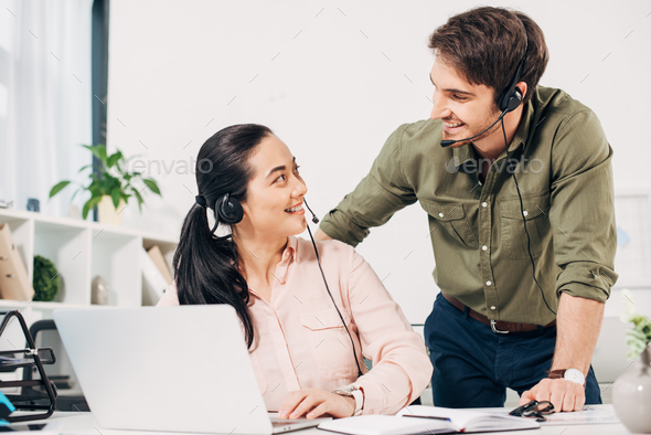 call center operators smiling and looking to each other in office Stock ...