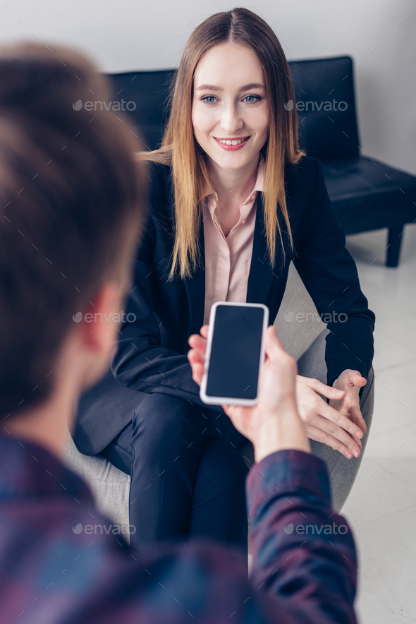 journalist recording interview with smiling businesswoman on smartphone ...