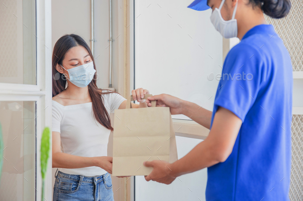 Delivery man wearing mask, deliver bag of food to customer Stock Photo ...