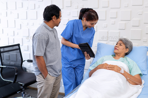 Nurse showing medical insurance data in digital tablet near bed of ...