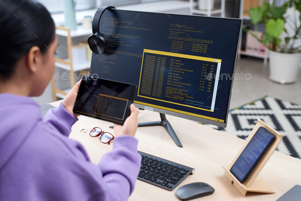 Female IT programmer holding tablet and writing code at workplace Stock ...