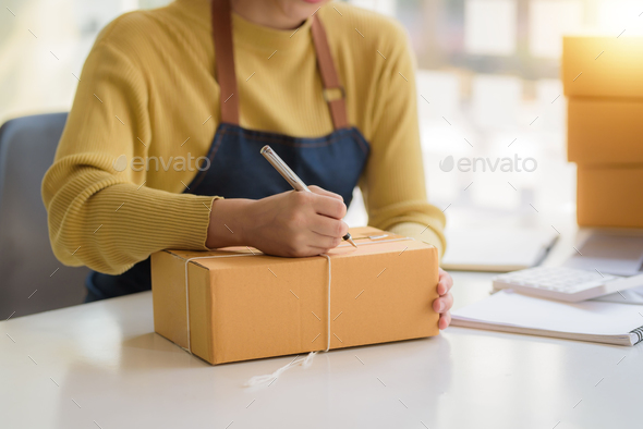 Online sales business owner woman is taking note of the customer's ...